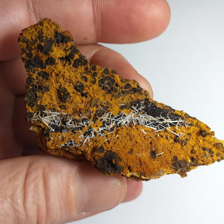 CERUSIT sekundární uhličitan olova (PbCO3). Bílé jehlice na hnědém ...